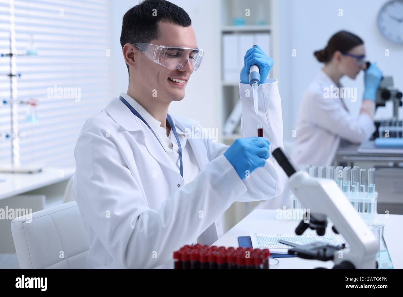 Scientist dripping sample into test tube in laboratory Stock Photo - Alamy