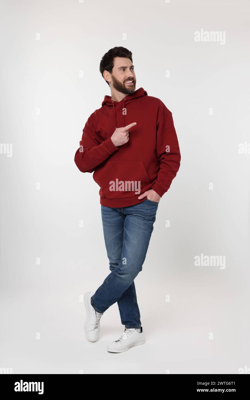 Happy man pointing at something on white background Stock Photo - Alamy