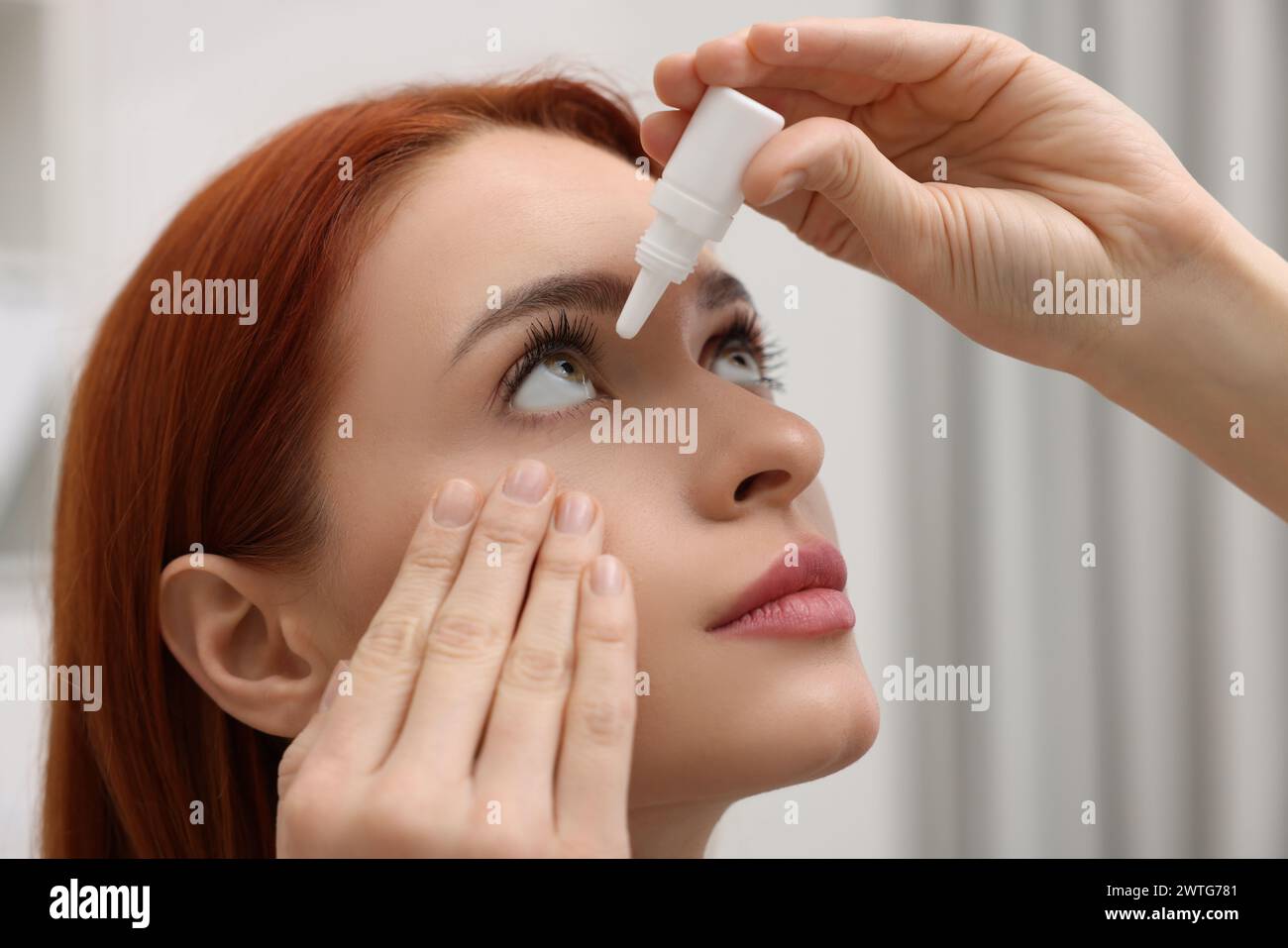 Woman applying medical eye drops at home Stock Photo - Alamy