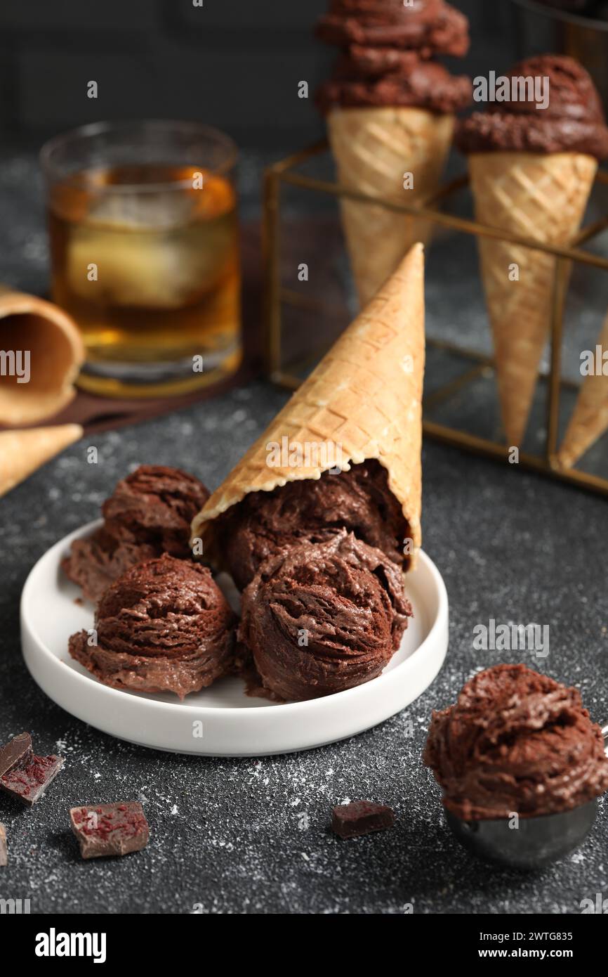 Tasty ice cream scoops, chocolate crumbs and waffle cones on dark ...