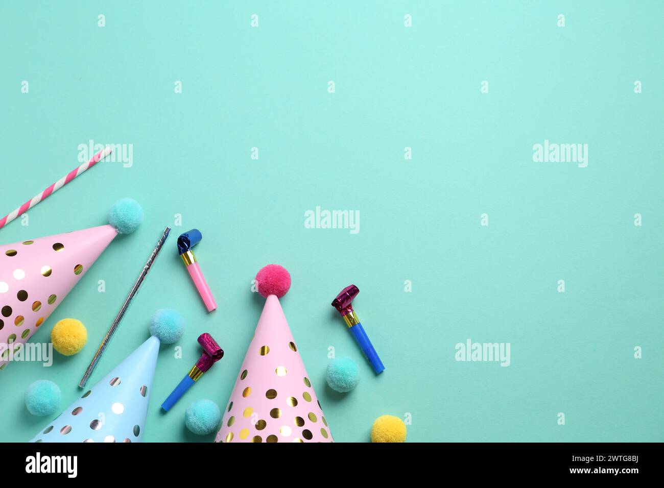 Party hats and other bright decor on turquoise background, flat lay ...