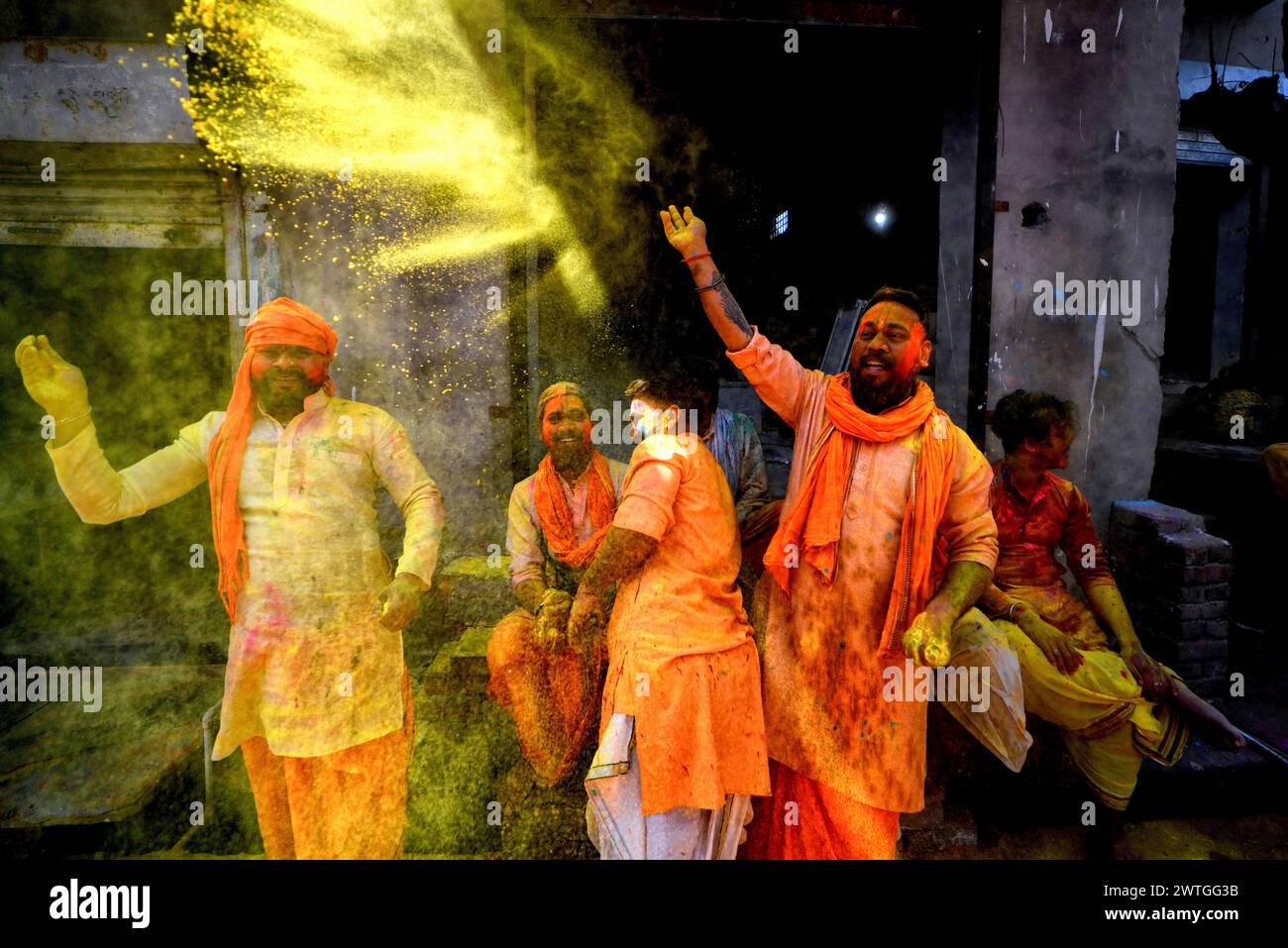 Mathura, India. 17th Mar, 2024. Devotees throw colour powder at each ...