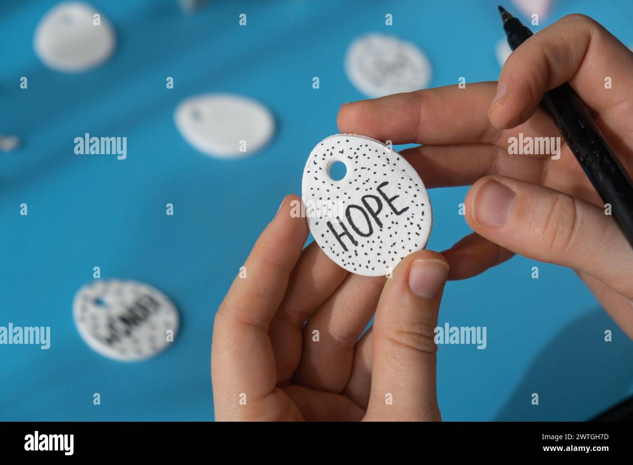 Workshop writing word HOPE on EASTER egg Creator is using white air dry ...