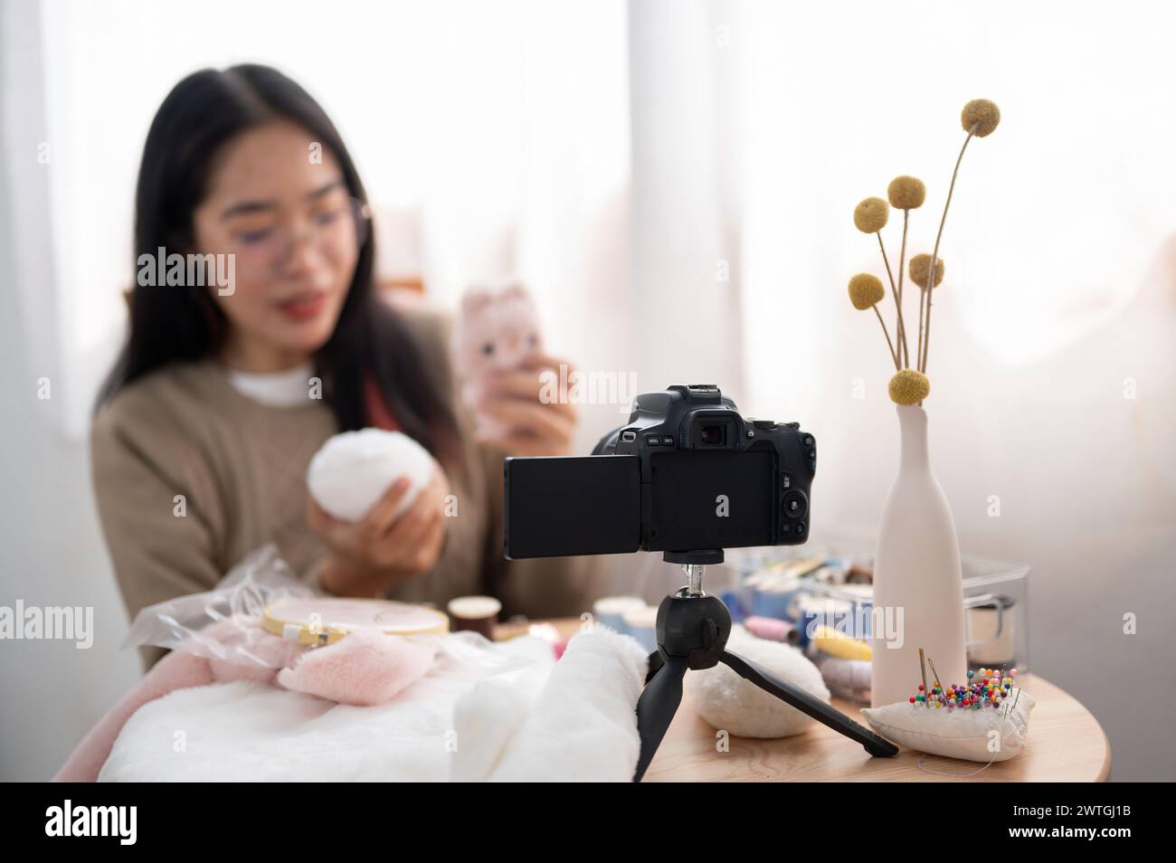 A smiling, cheerful young Asian female content creator is talking with ...