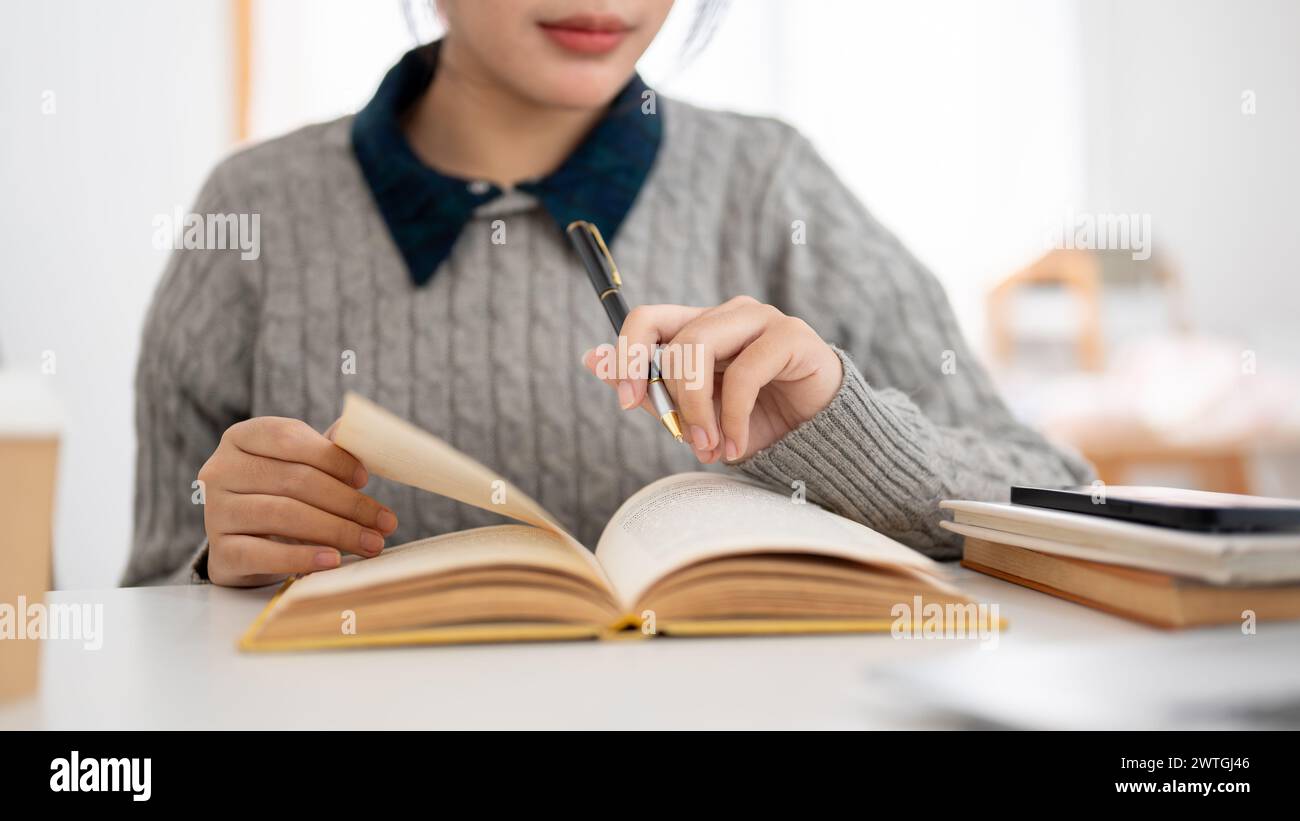 A cropped image of a young Asian female student is focusing on her ...