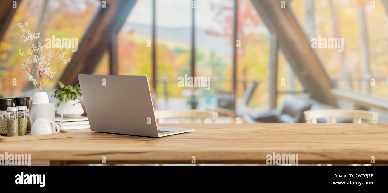 A back view image of a laptop computer on a wooden dining table in the ...