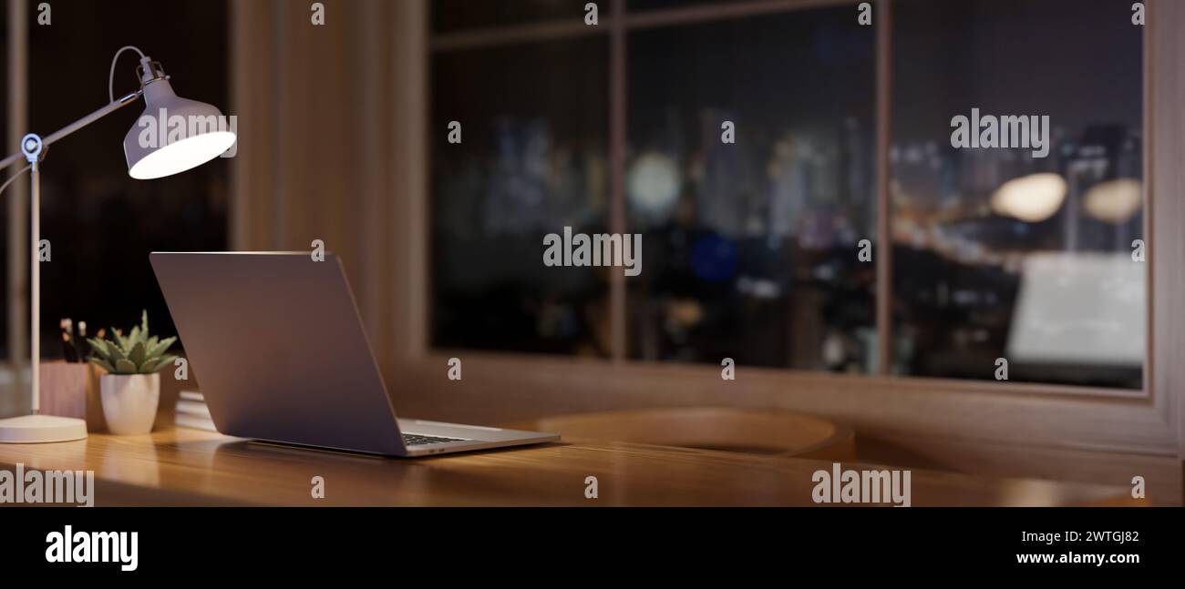 A laptop computer on a wooden desk in a contemporary room at night ...