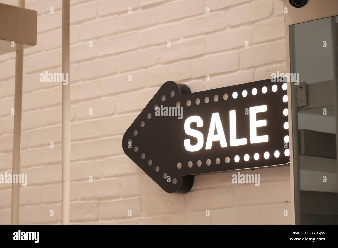 sale sign with arrow hanging on wall Stock Photo - Alamy