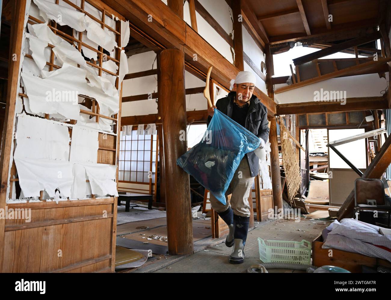 Chikayoshi Takezono remove debris from his house damaged by the Noto ...