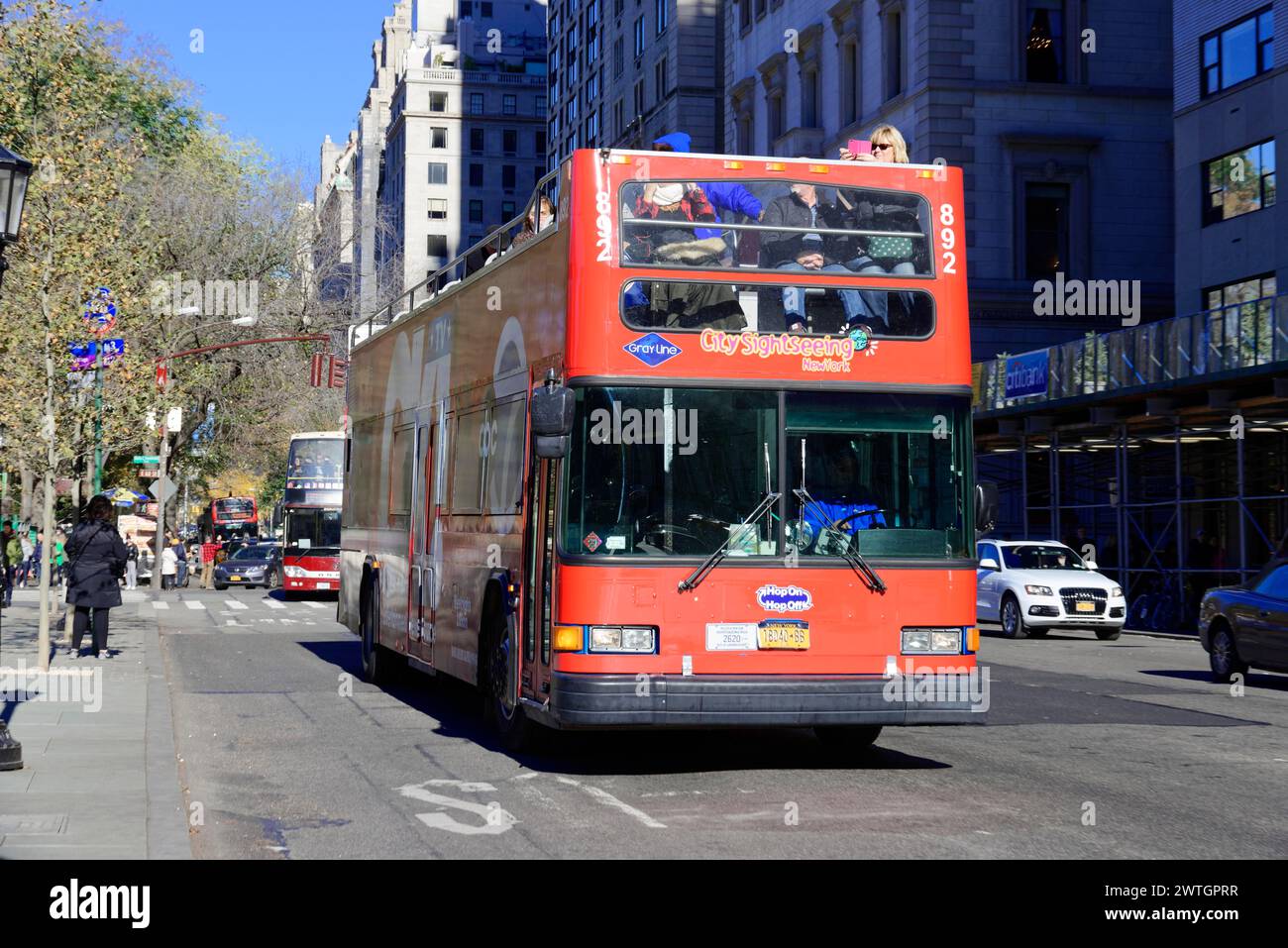 A red double-decker city bus drives on a city street, Manhattan, New ...