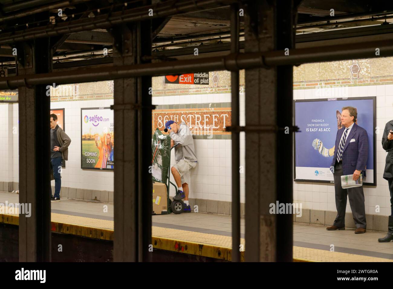 People waiting on the platform of an underground station next to ...