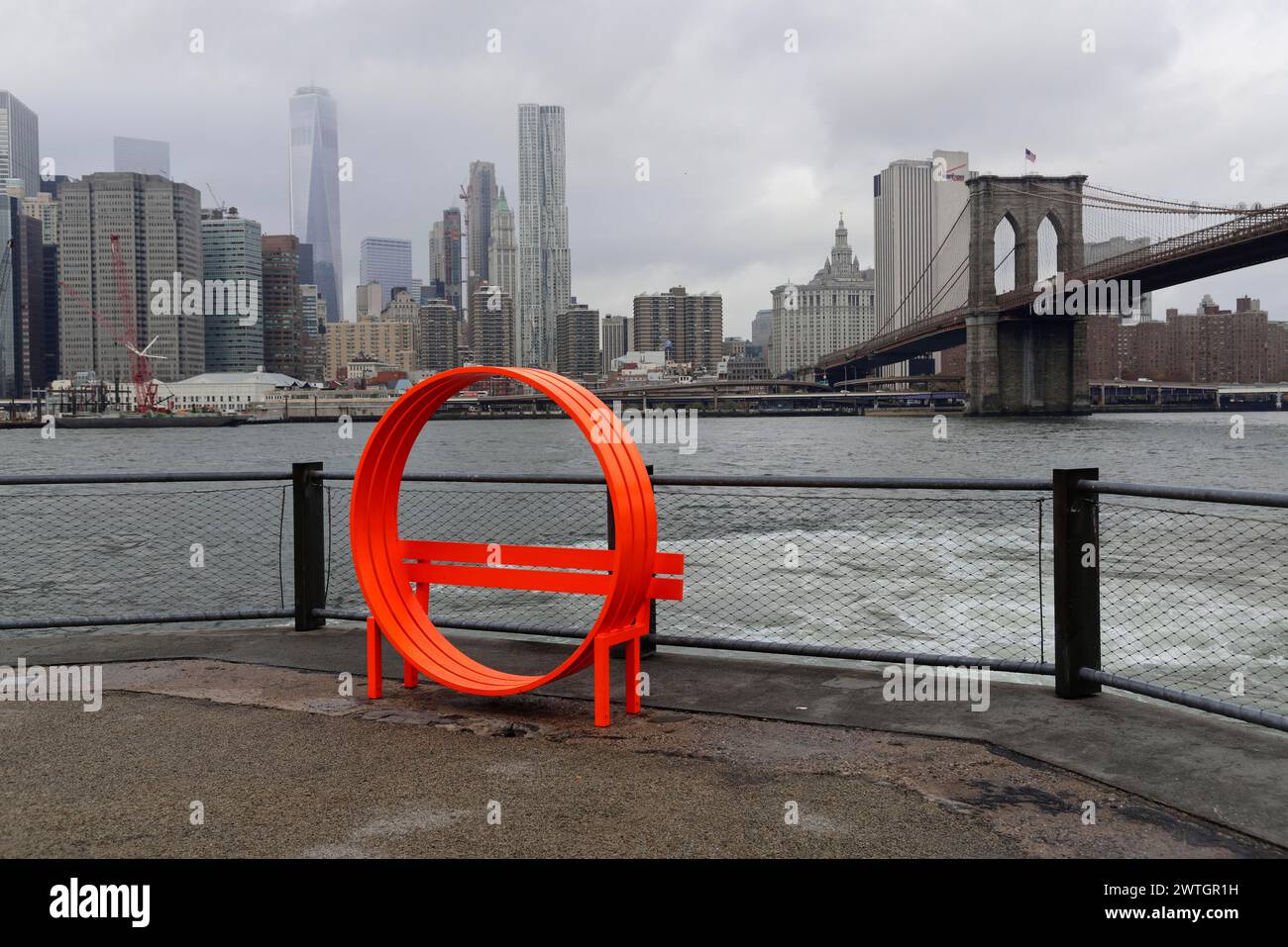 Modern red sculpture in the foreground with a view of the Brooklyn ...