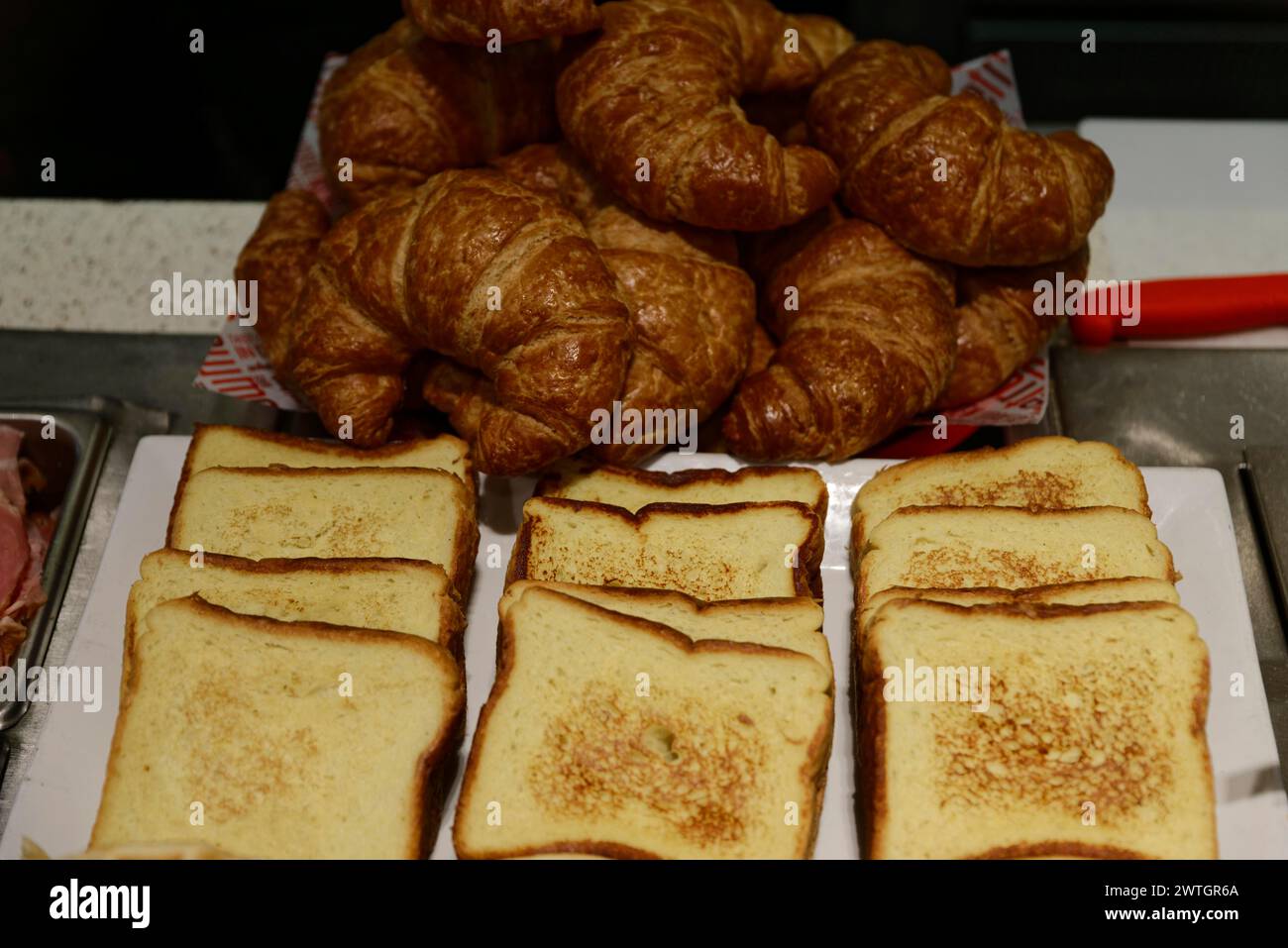 Fresh, golden yellow croissants next to slices of brioche, Manhattan ...