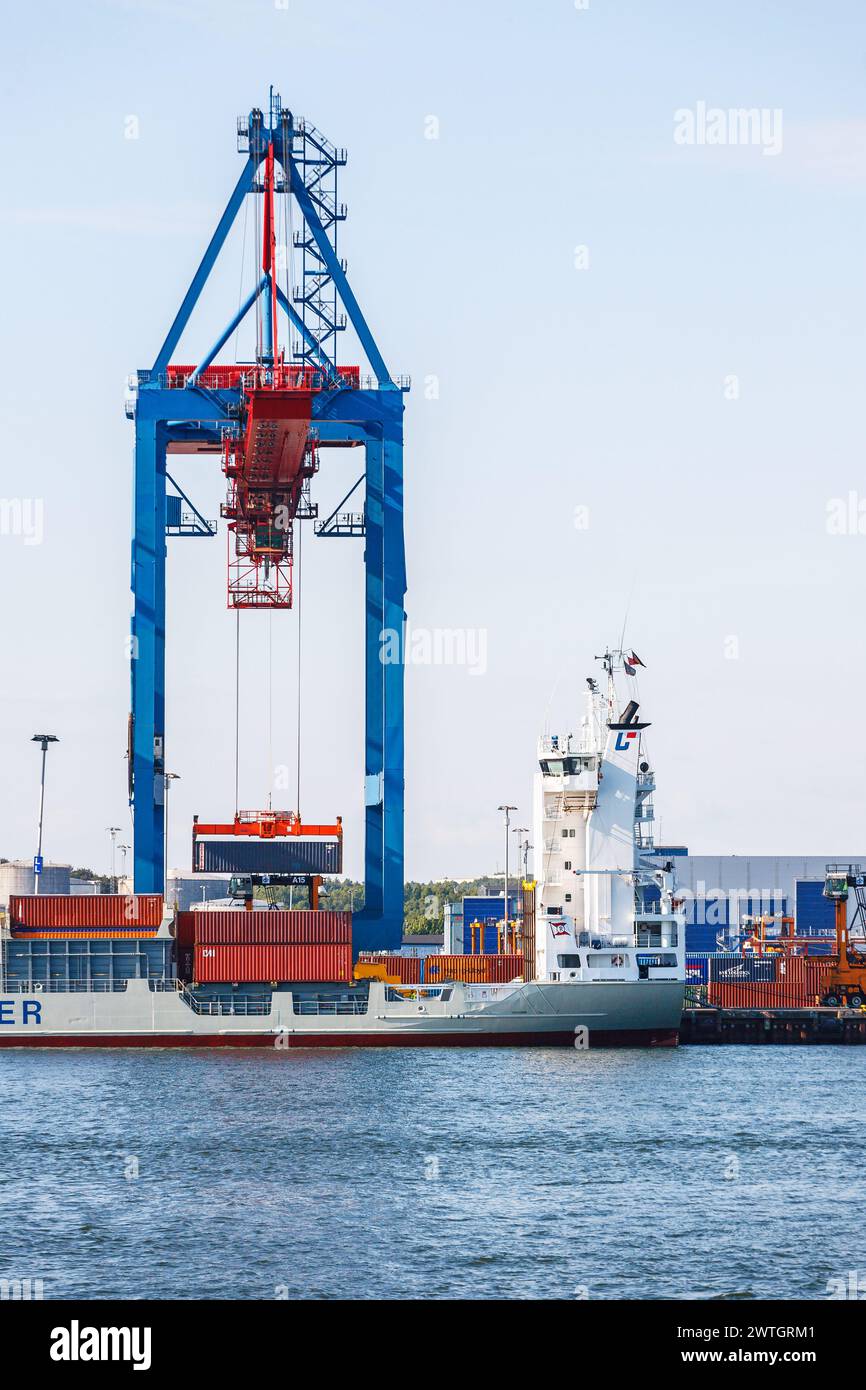 Container terminal gantry crane lifting cargo container in sea port hi ...