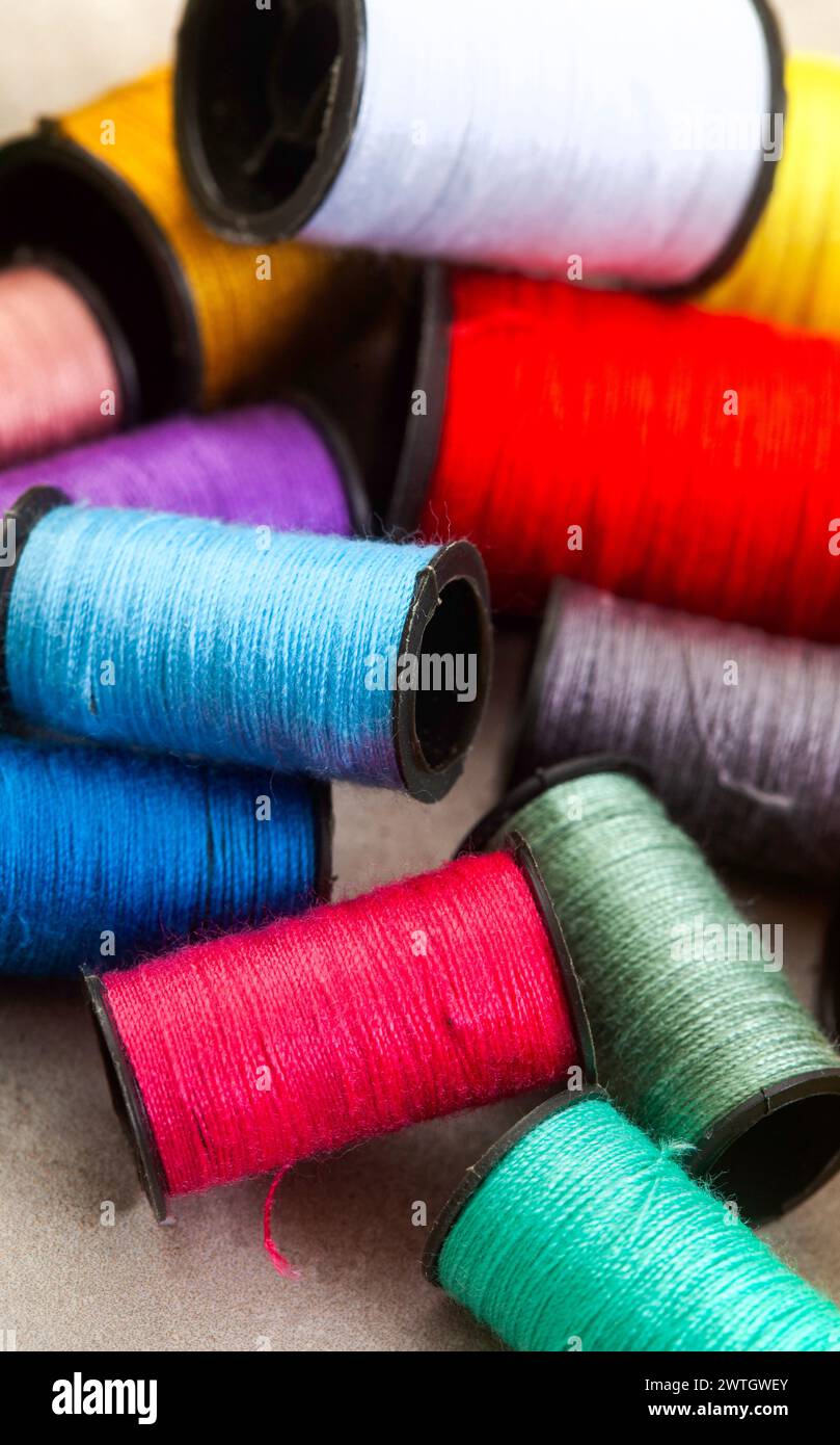 collection of various spools of colorful sewing thread on white, with ...