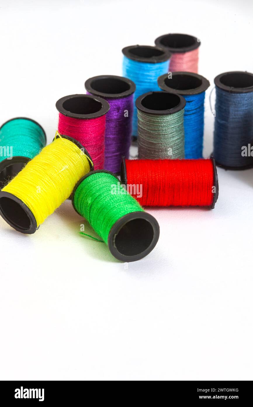 collection of various spools of colorful sewing thread on white, with ...