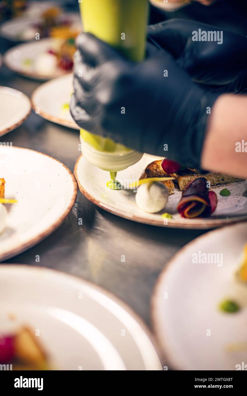 Chef finishing his plate and almost ready to serve at the table Stock ...