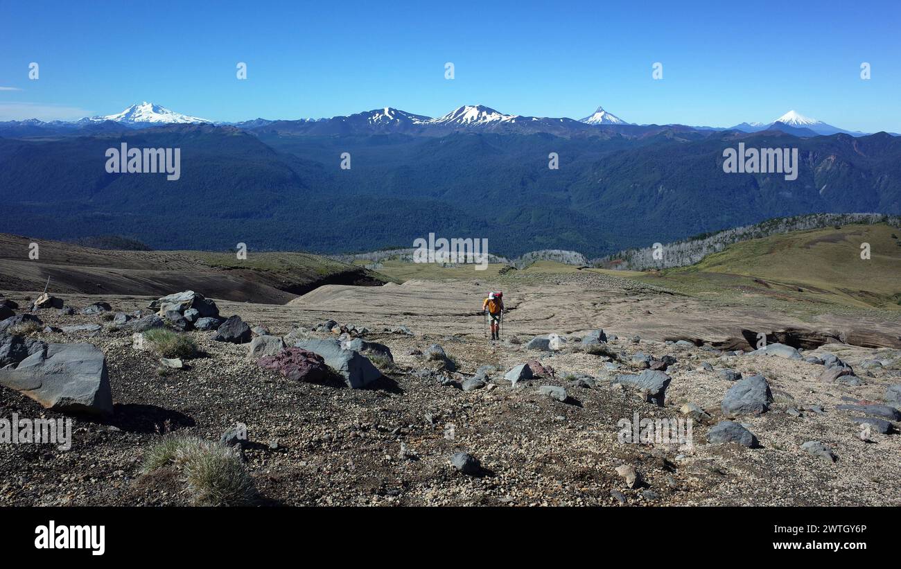 Man solo hiking up mountainside volcano Puyehue, Puyehue National Park ...