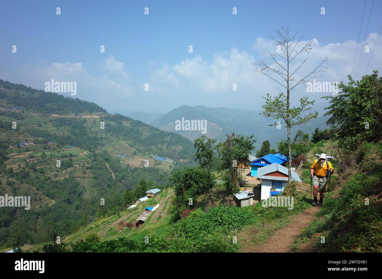 Trekking in Nepal Himalayas. Male tourist hiking on green mountain near ...