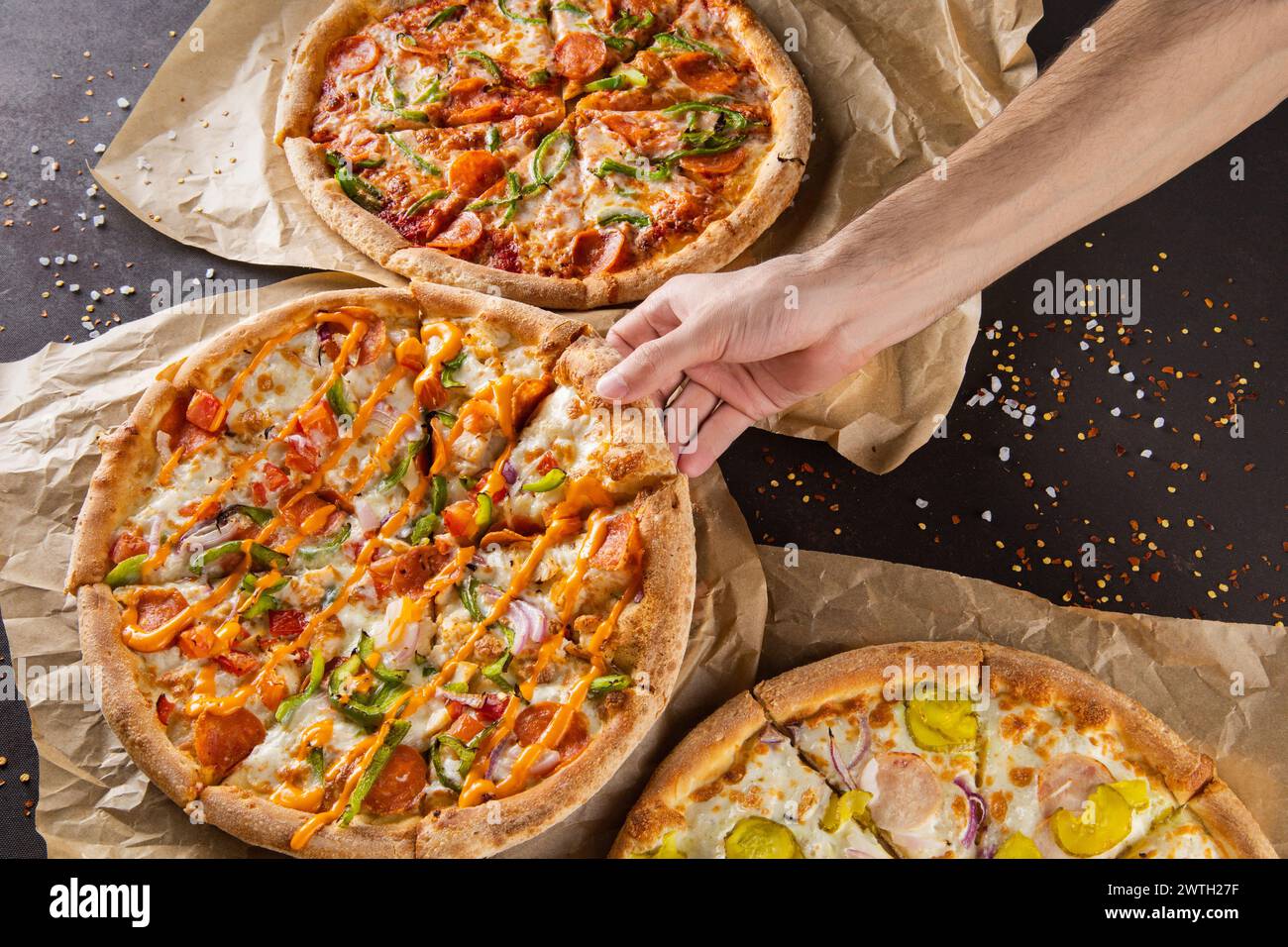 a man's hand pulls a piece of one of three delicious beautiful colorful ...