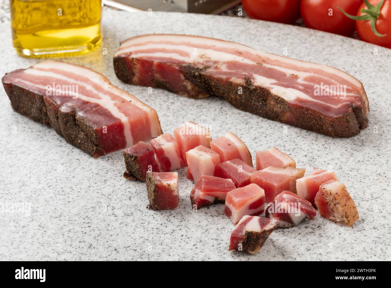 Slice and cubes of Italian pancetta on a cutting board close up Stock ...