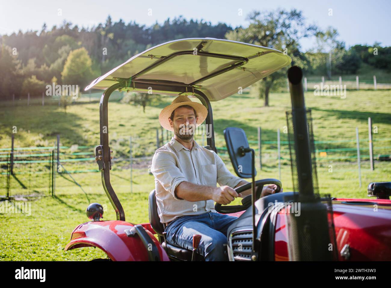 Farmer riding tractor on field. Harvesting crops, collecting vegetables ...