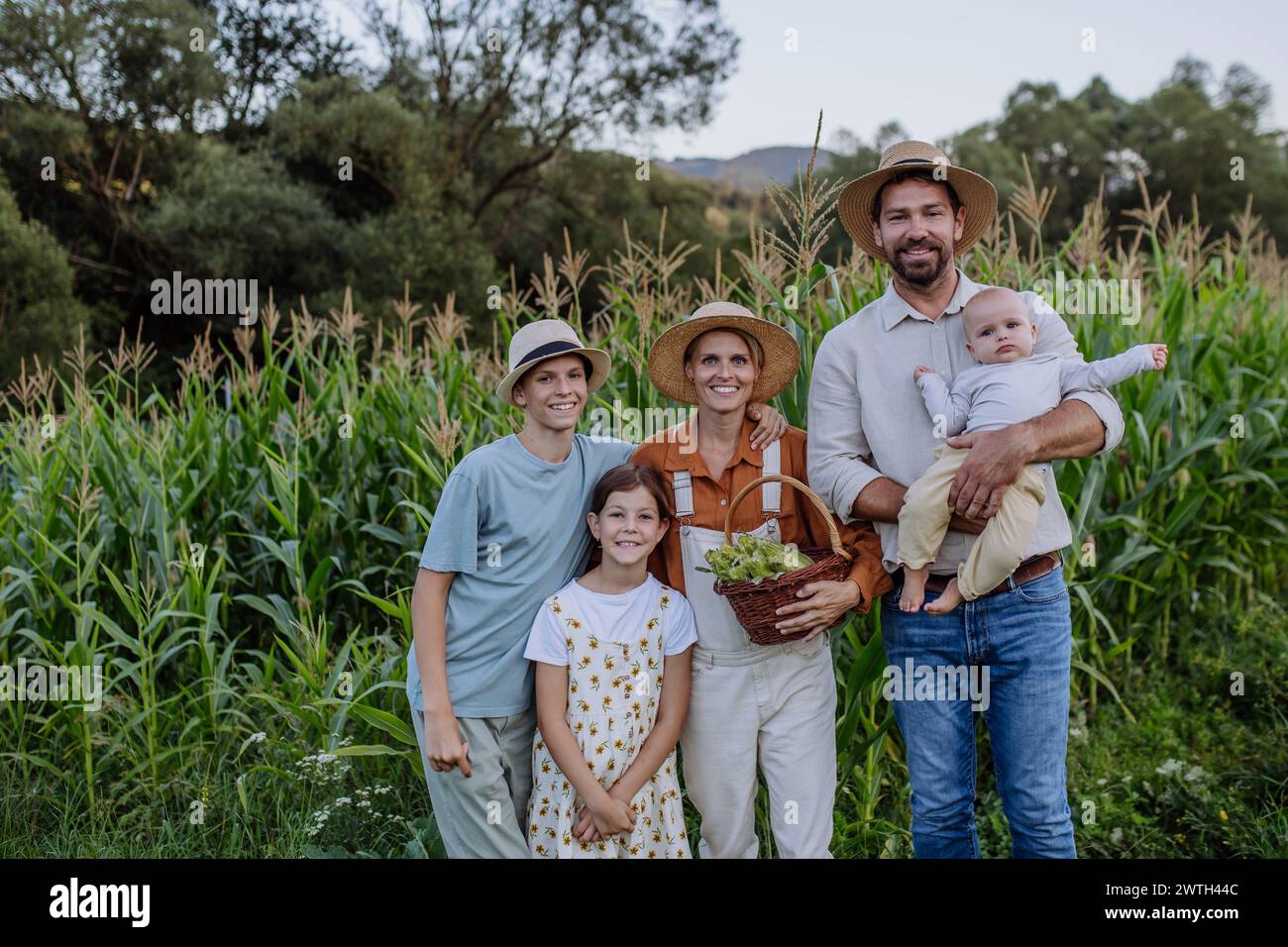 Farmer family standign in front of field with corn. Concept of ...