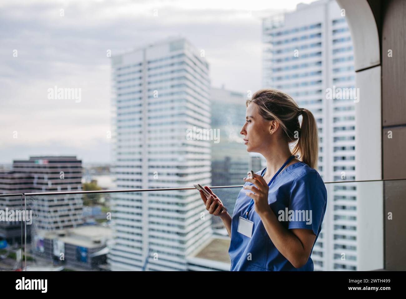 Nurse smoking cigarette at balcony after work. Doctor feeling ...