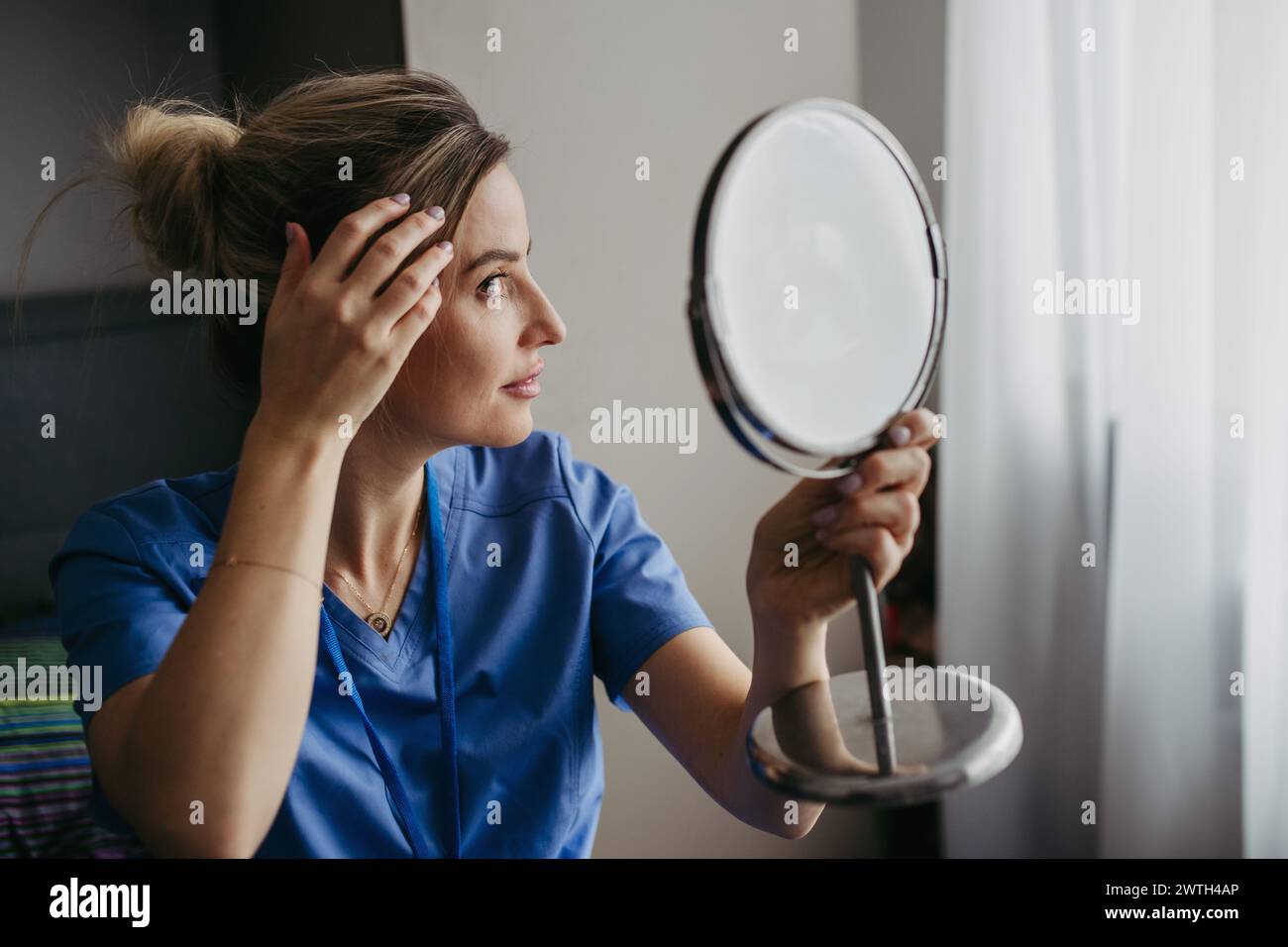 Female nurse or doctor getting ready for work in the morning, brushing ...
