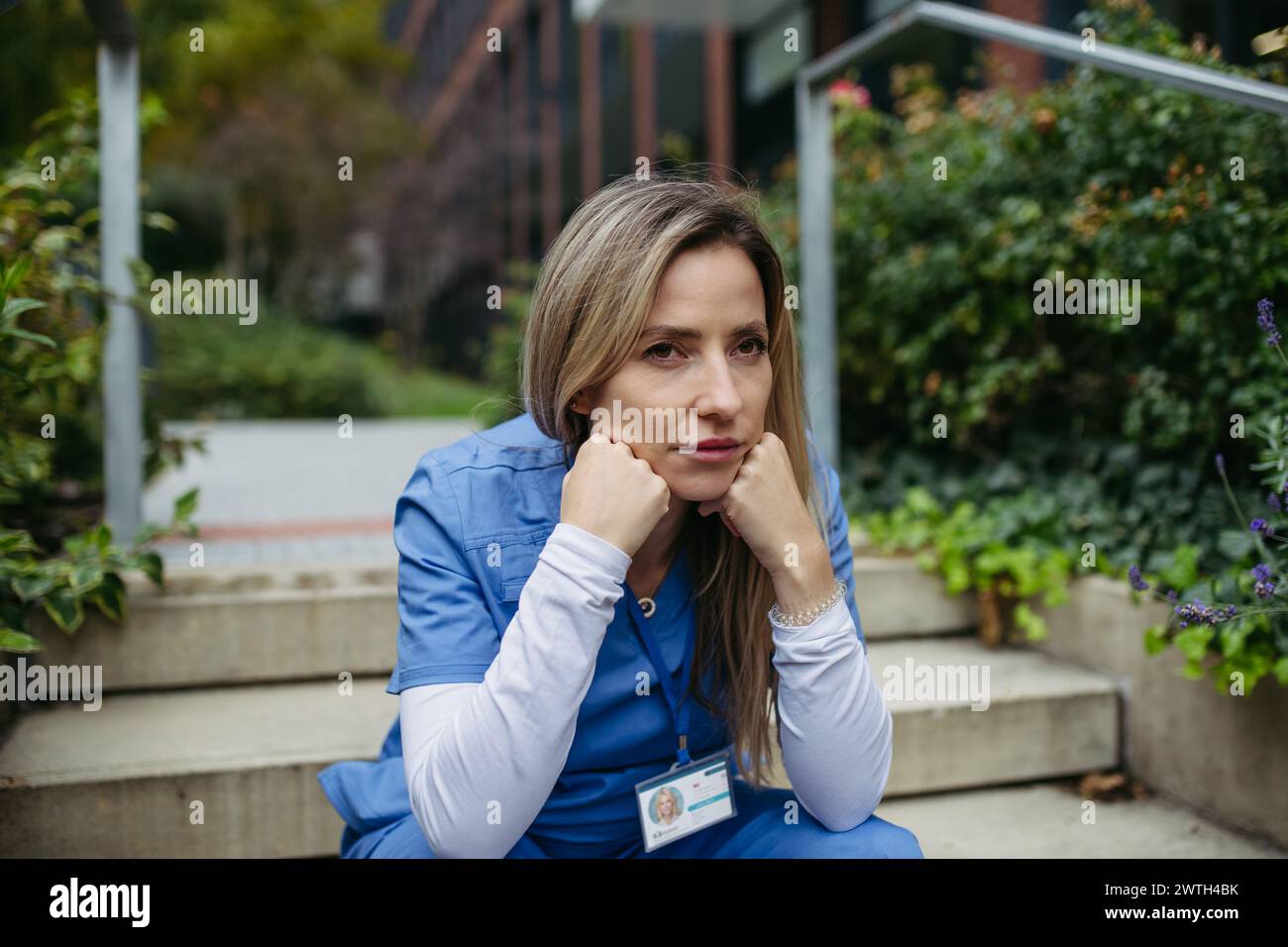 Female doctor feeling overwhelmed at work, sitting on stairs ...