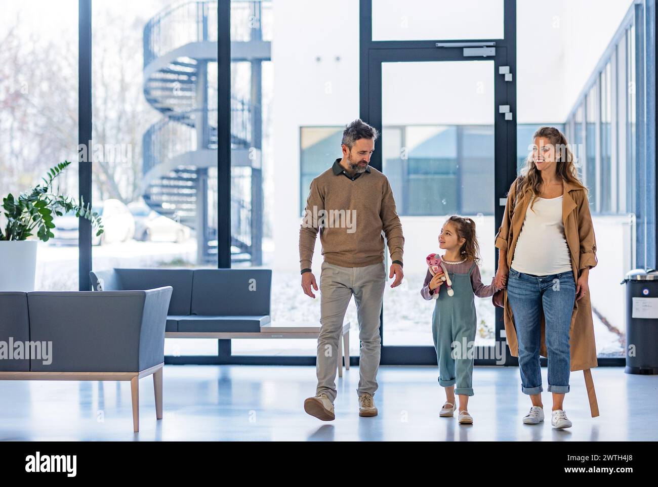 Girl patient coming for examination in a modern clinic with her parents ...