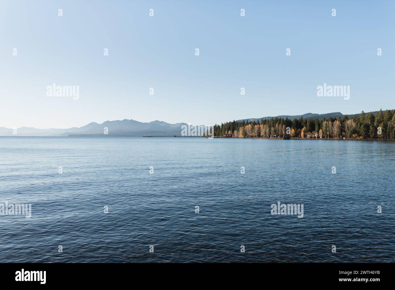 Deep blue waters with forest shoreline & mountain ranges at Lake Tahoe ...