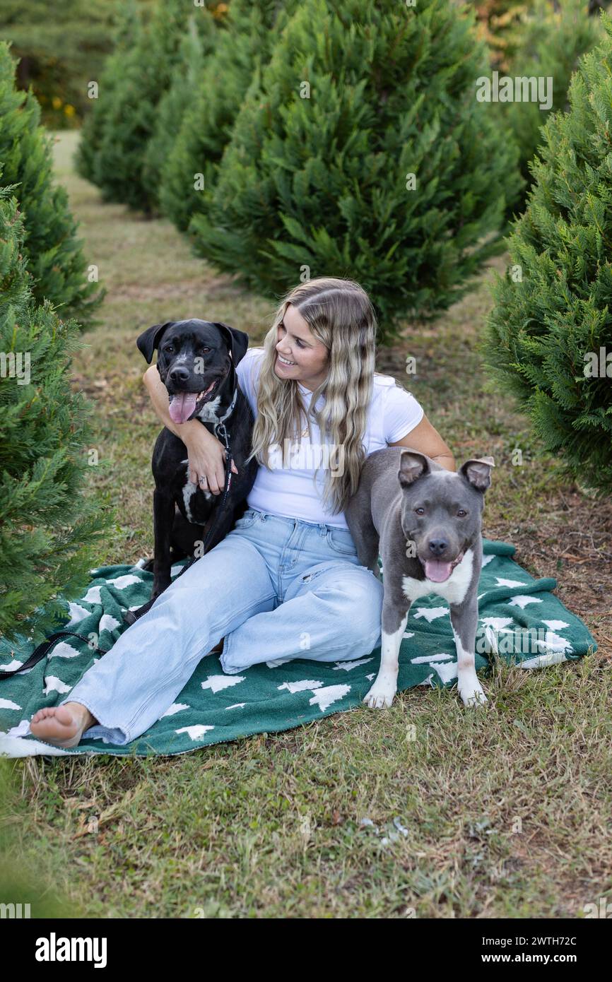 Blonde (33) girl hugs and smiles at her pit rescue dogs in tree farm ...