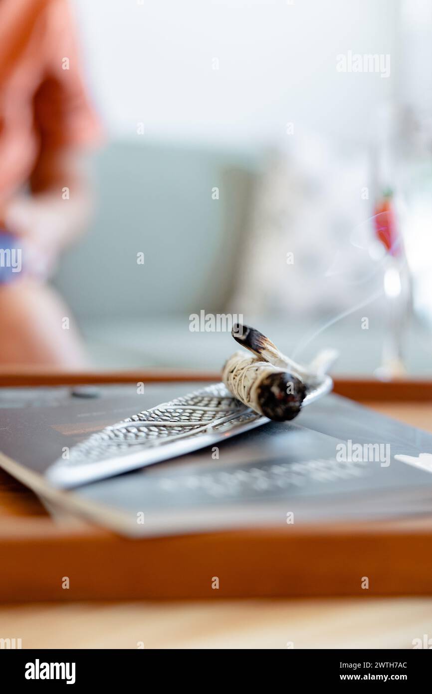 lighting sage burning on blue couch in neutral room Stock Photo - Alamy