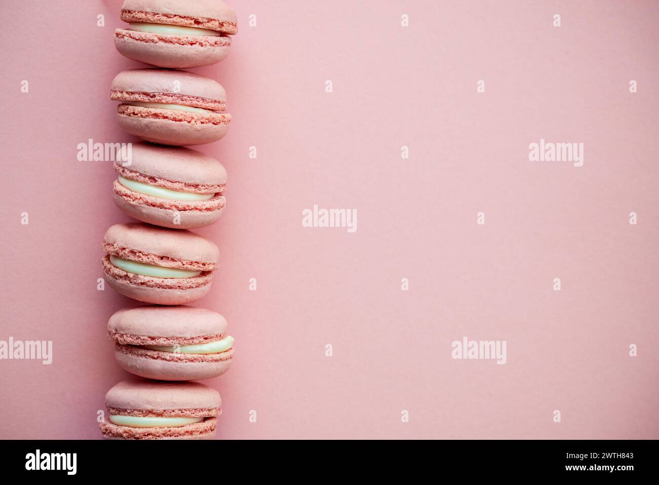 Pink macarons stacked in a vertical line on a pastel background Stock ...
