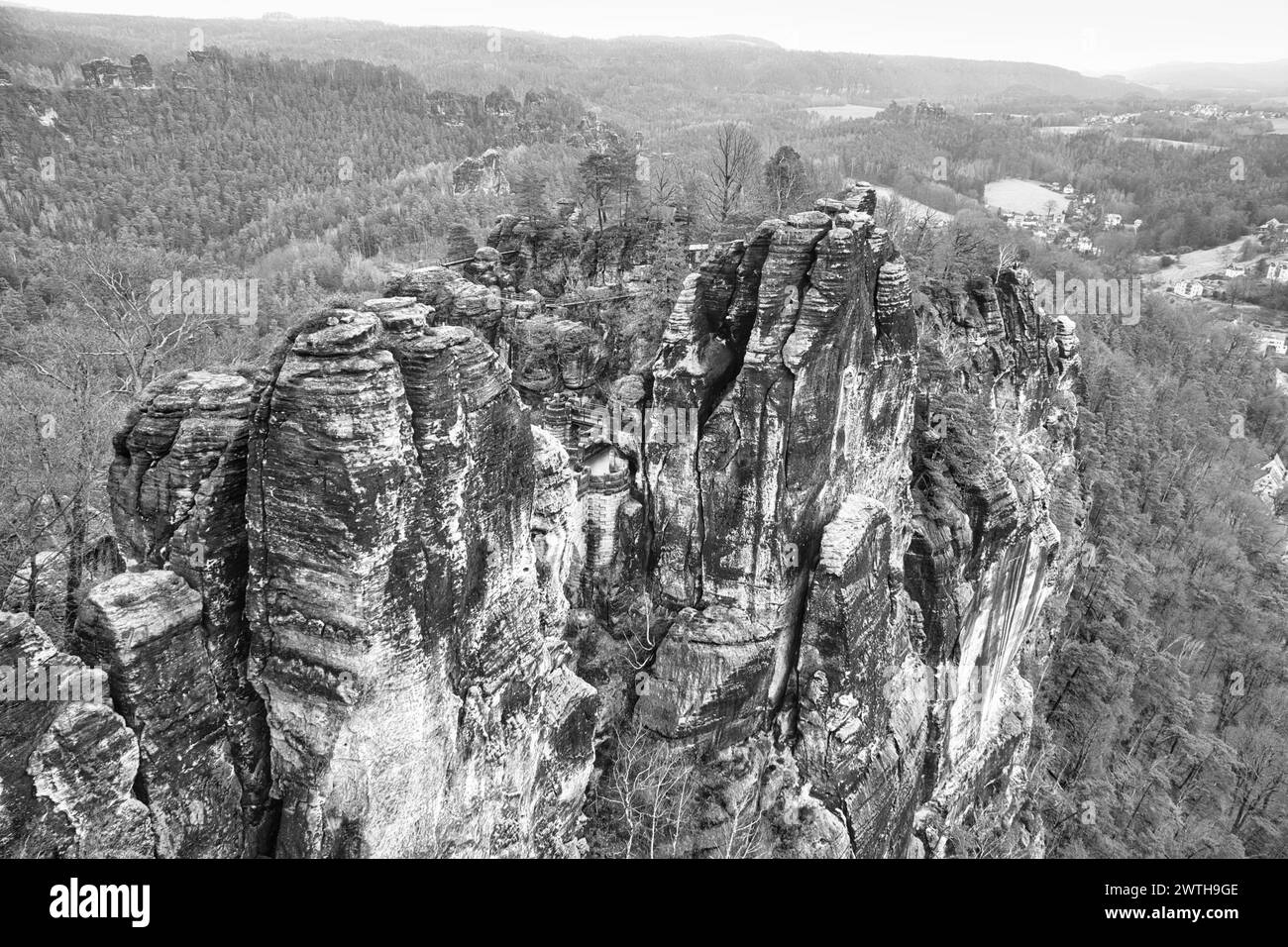 Jagged rocks at the Basteibridge. Wide view over trees and mountains ...