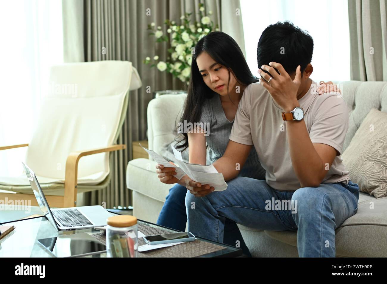 Stressed young couple having financial problems, looking worried about ...