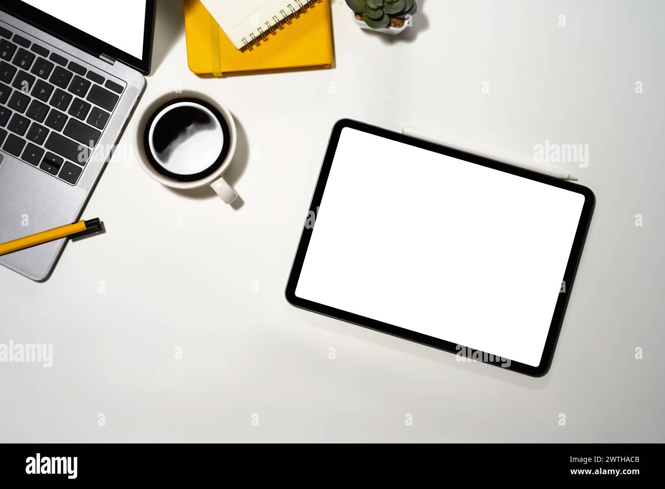 Top view digital tablet with empty display, coffee cup and laptop on ...