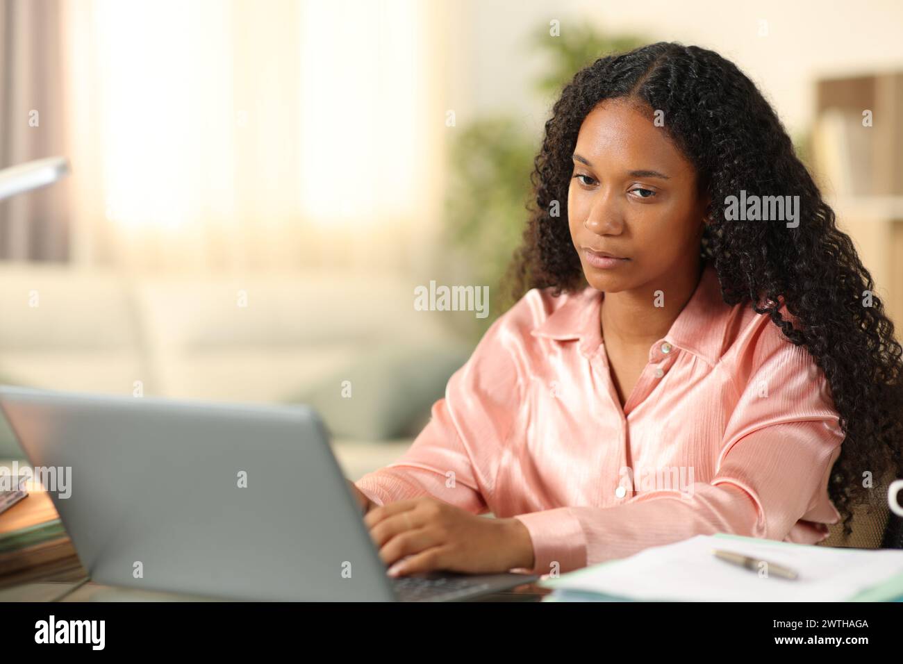 Distracted black tele worker looking away working online at home Stock ...