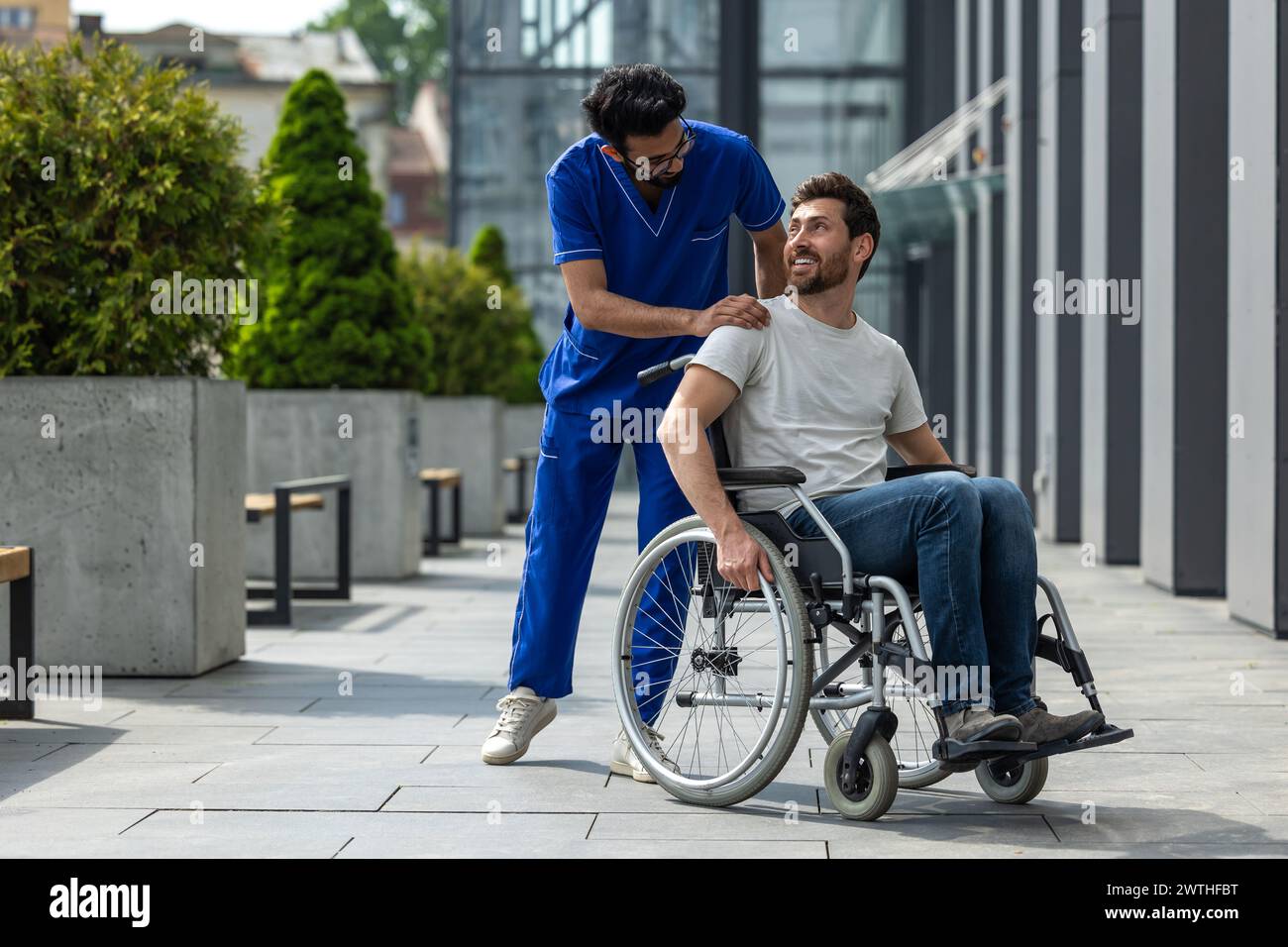 Tall bearded male nurse carrying the patient on a wheelchair Stock ...