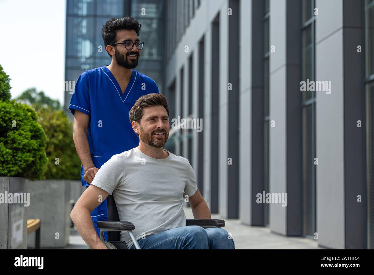 Tall bearded male nurse carrying the patient on a wheelchair Stock ...