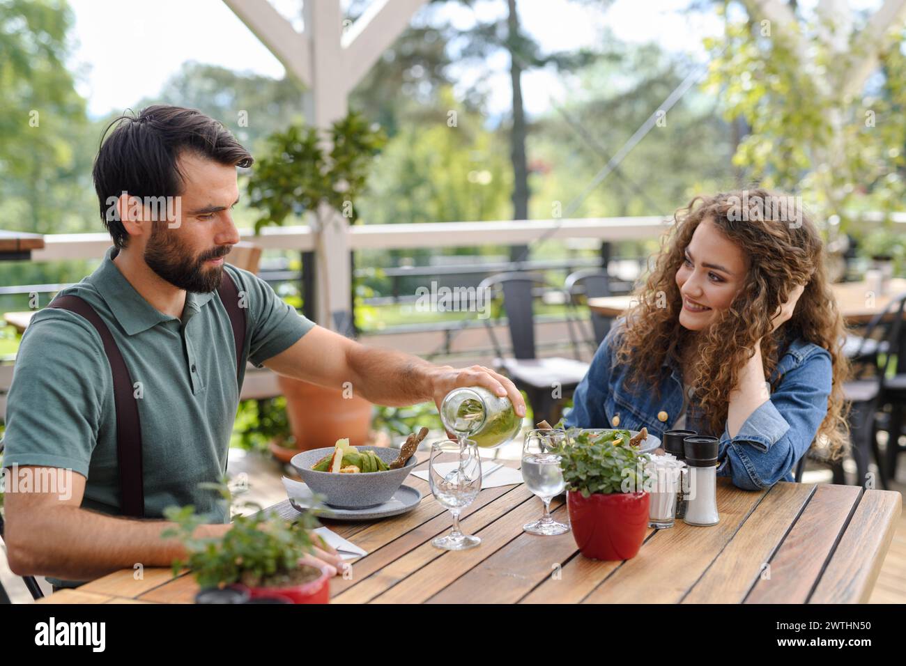 Young couple at date in restaurant, sitting on restaurant terrace ...
