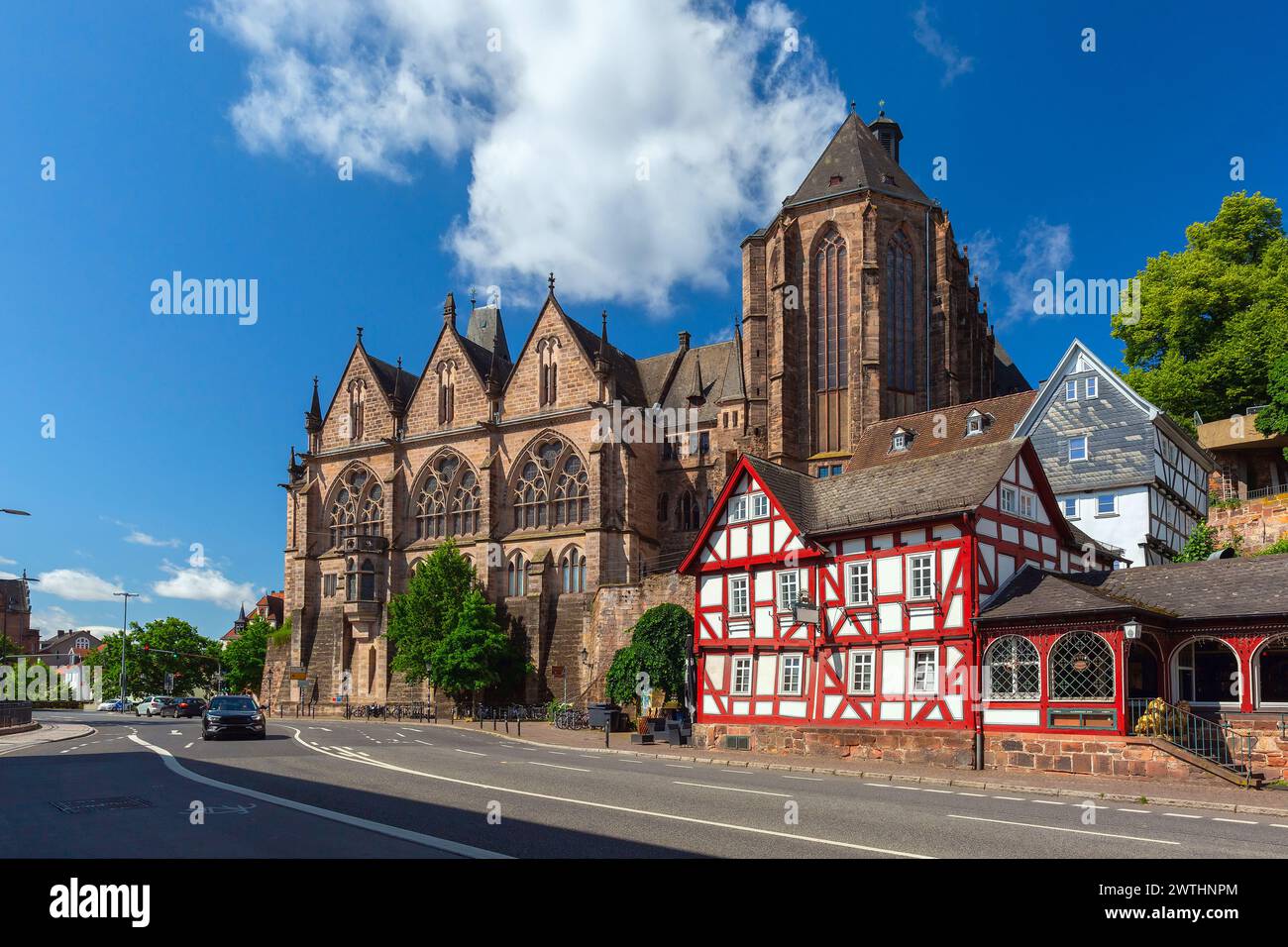Medieval street with traditional half-timbered houses and University ...