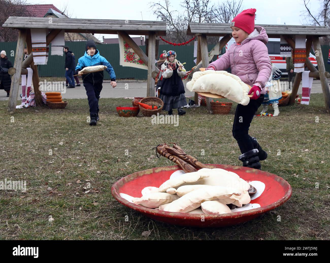 KYIV, UKRAINE - MARCH 16, 2024 - Children carry fake dumpling models ...