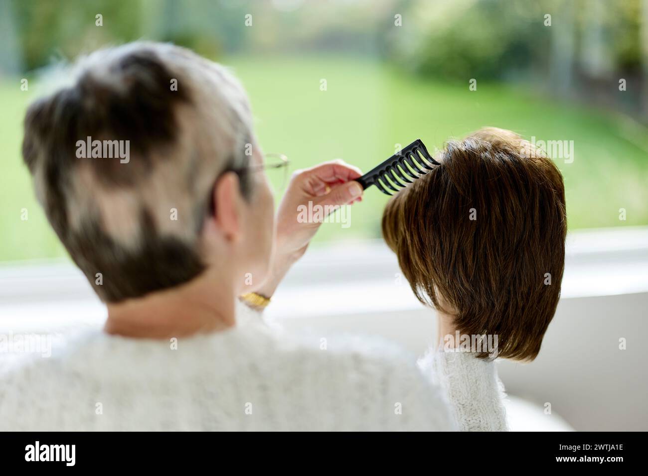 Woman with Alopecia combing a wig Stock Photo - Alamy