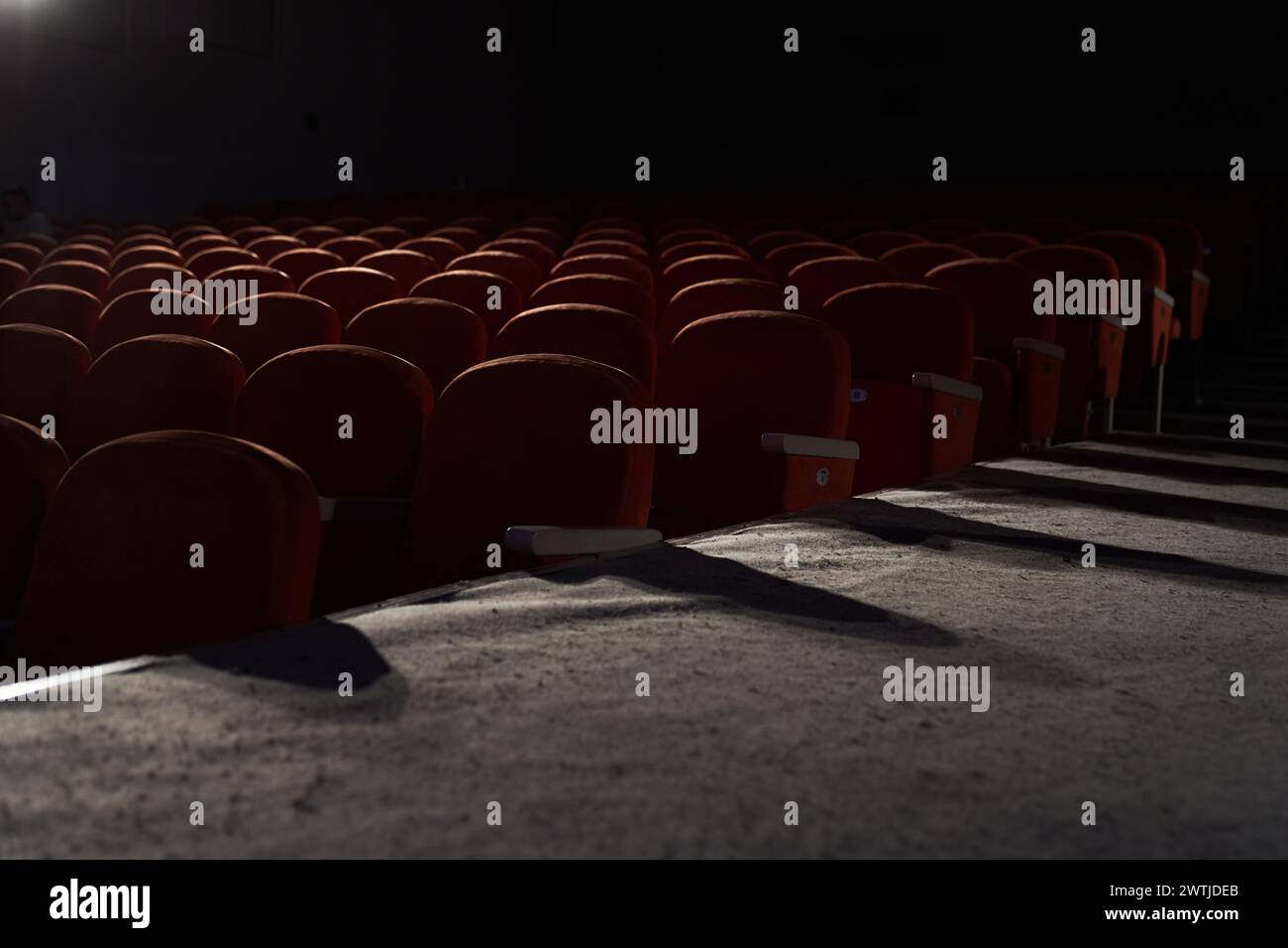 Side view of orange, red seats in dark cinema hall with copy space ...
