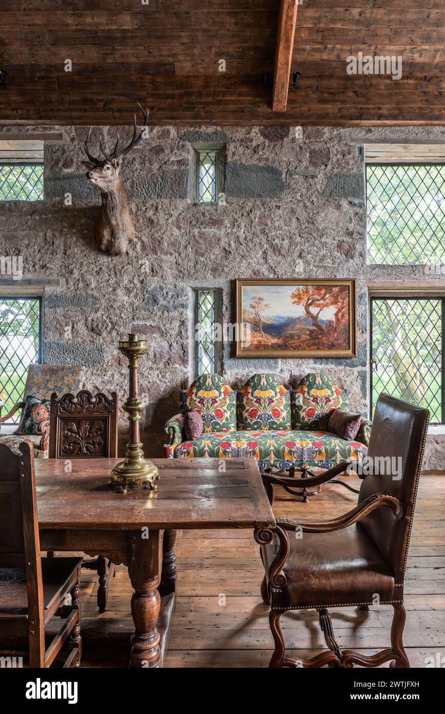 Leather ding chair at table with wall mounted stag's head in luxury ...