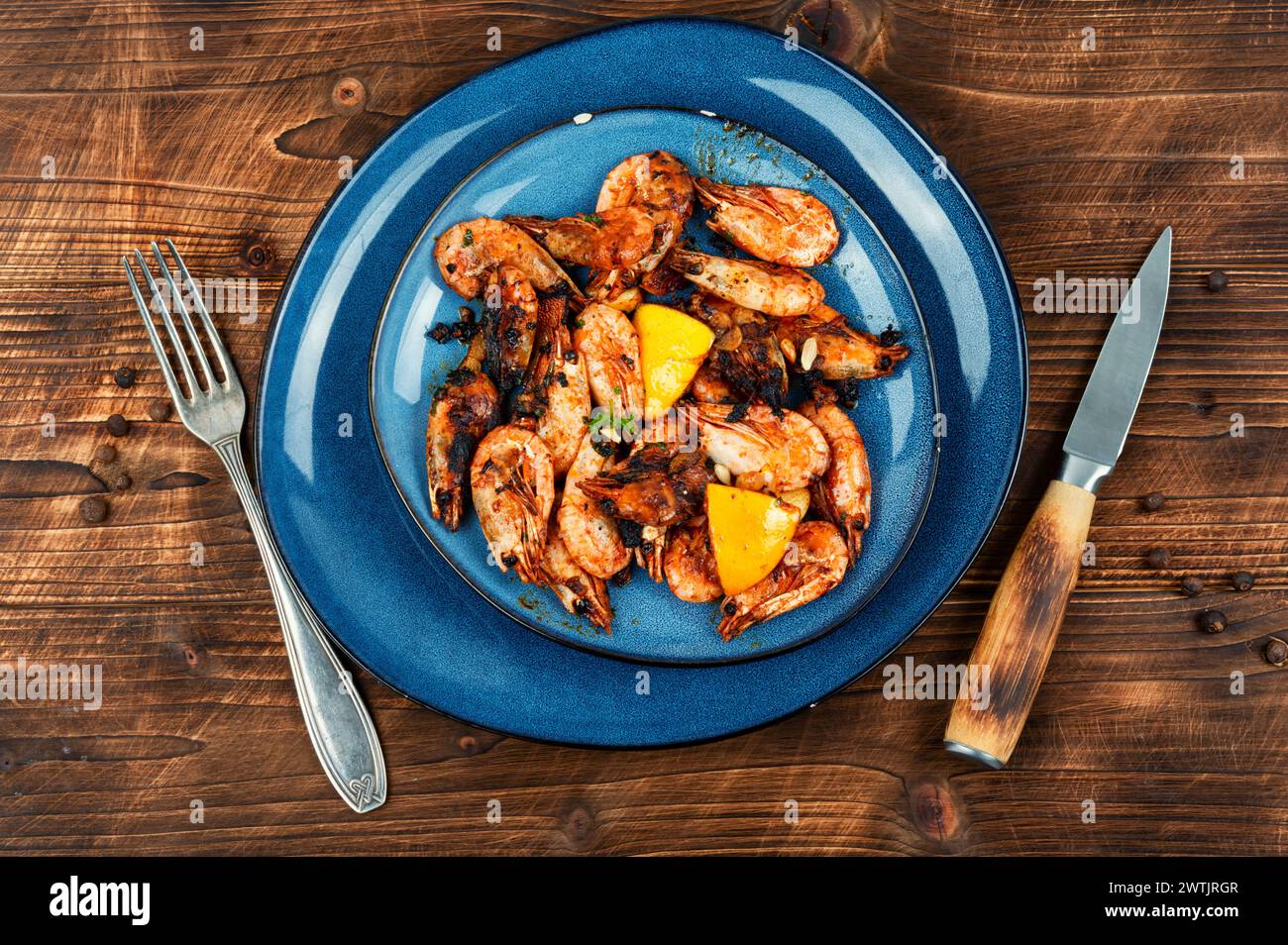 Roasted unpeeled shrimp on a plate. Dark rustic wooden background Stock ...