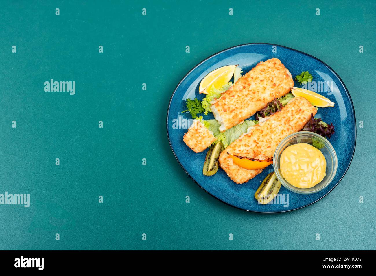 Pollock fillet roasted in bread crumbs and with kiwi. Fish. Space for ...