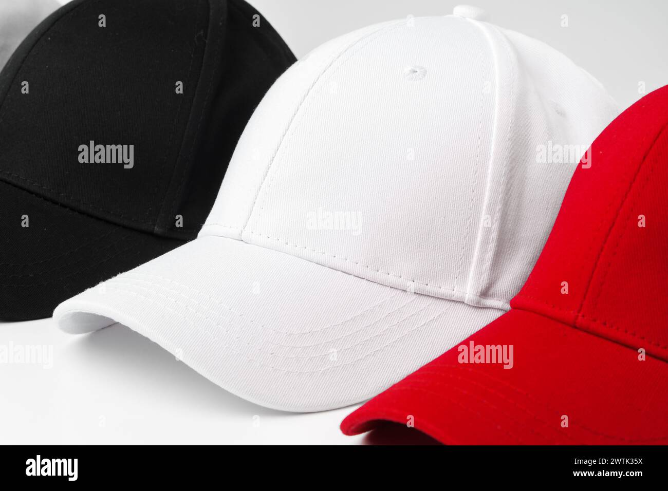 Lineup of Four Blank Baseball Caps in Red, White, and Black on a White ...
